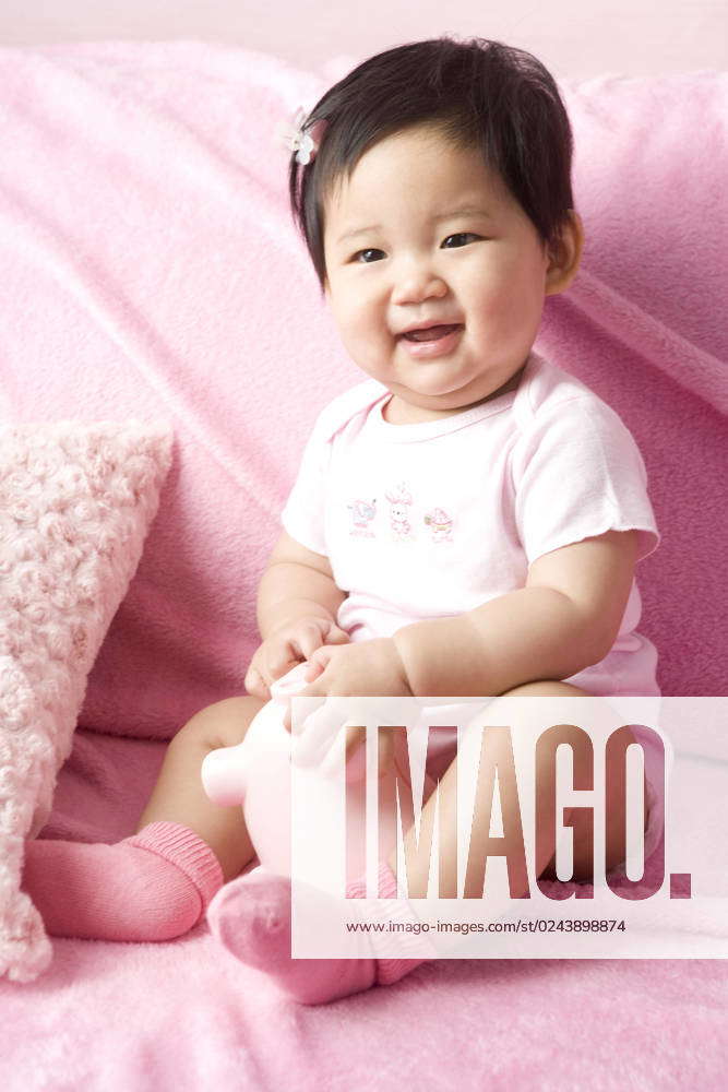 Chinese baby playing with the piggybank Beijing China