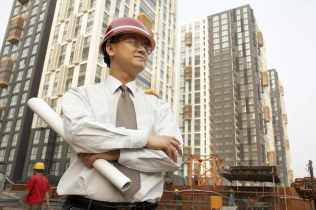 Chinese Construction Contractor Holding Building Plans, Looking Into ...
