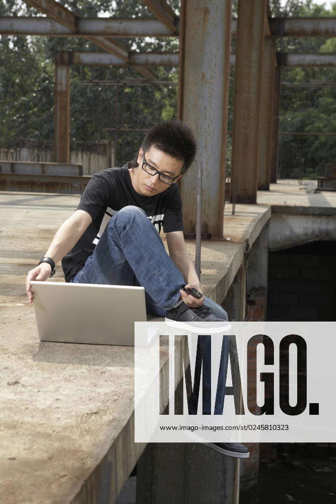 Chinese man looking at laptop computer Beijing China