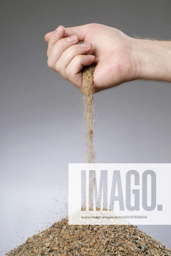 Man adding sand in a heap with his hand