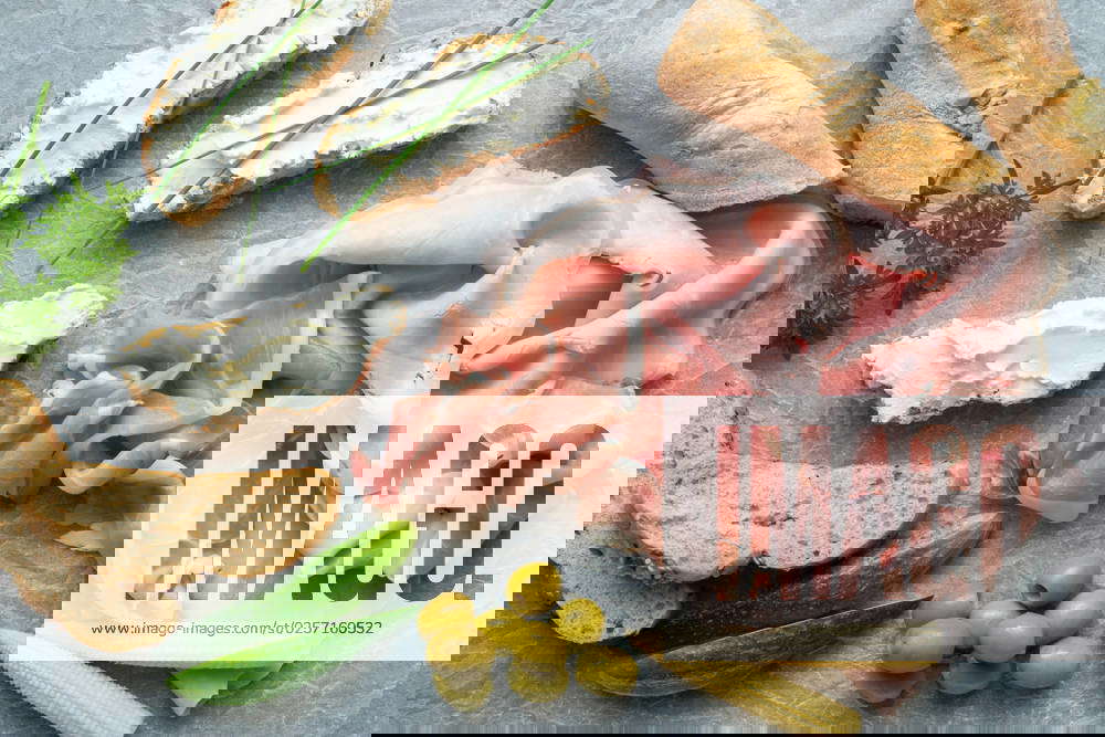 Cold appetizer. Cold cuts. Different snacks on a white crumpled paper ...