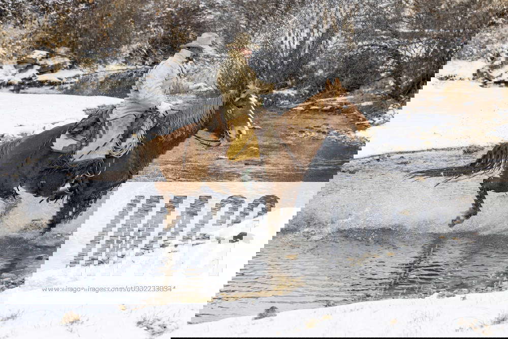 USA, Shell, Wyoming. Hideout Ranch lone cowboy riding fast across Shell