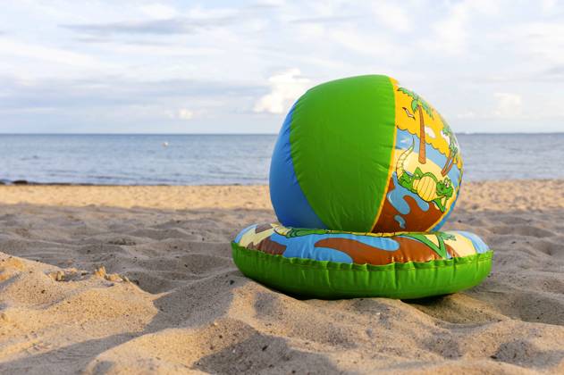 Bathing ball and swimming ring Numerous people spend their summer ...