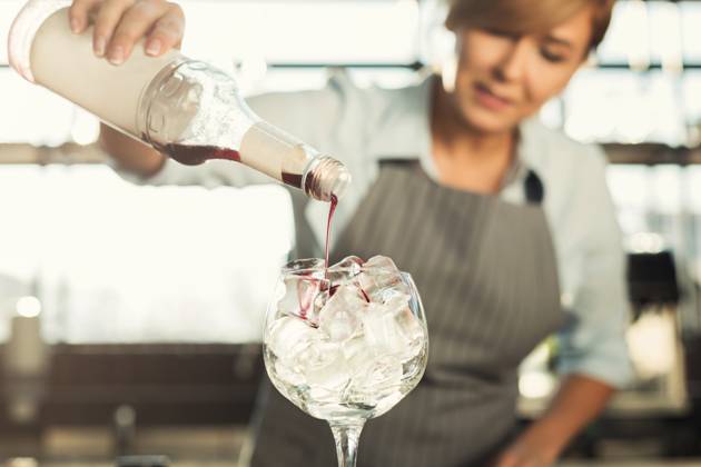 Experienced middle age barista doing alcohol cocktail in cafe. Woman ...