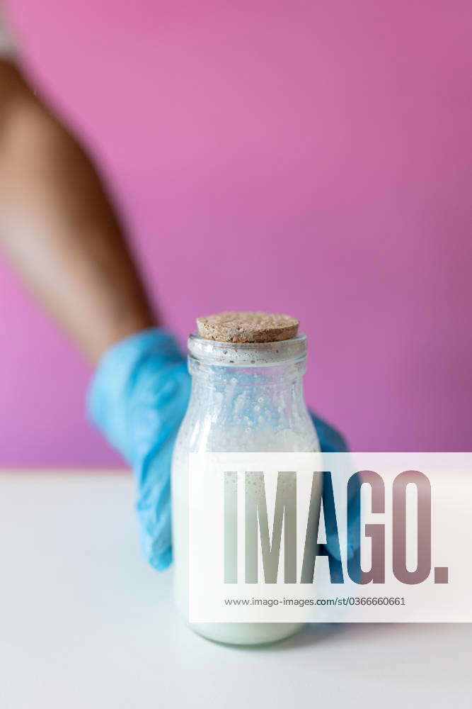 Close up of a worker grabbing a milk jar for making rolled ice cream ...
