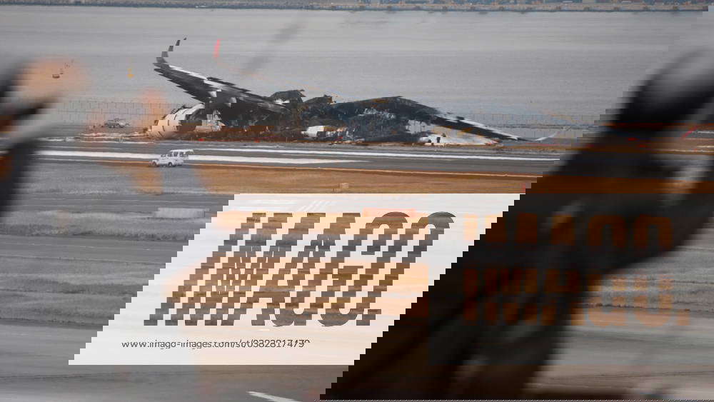 A man take photos at the burnt Japan Airlines (JAL) Airbus A350 plane ...