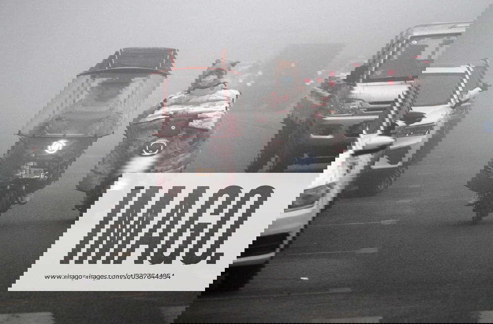 Heavy Fog Hit Linyi Pedestrians are riding in heavy fog on a street in ...