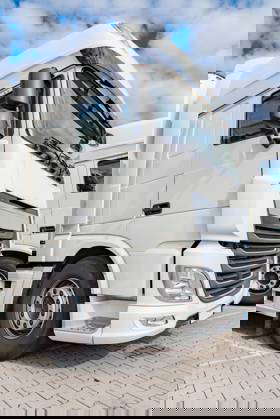 White tractor unit of a semitrailer is parked in the yard of a haulage ...