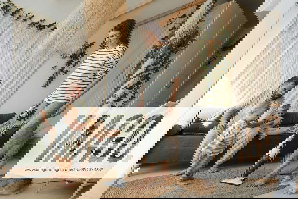 IMAGO Creative: Frühjahrsputz Mother vacuuming the living room at home ...