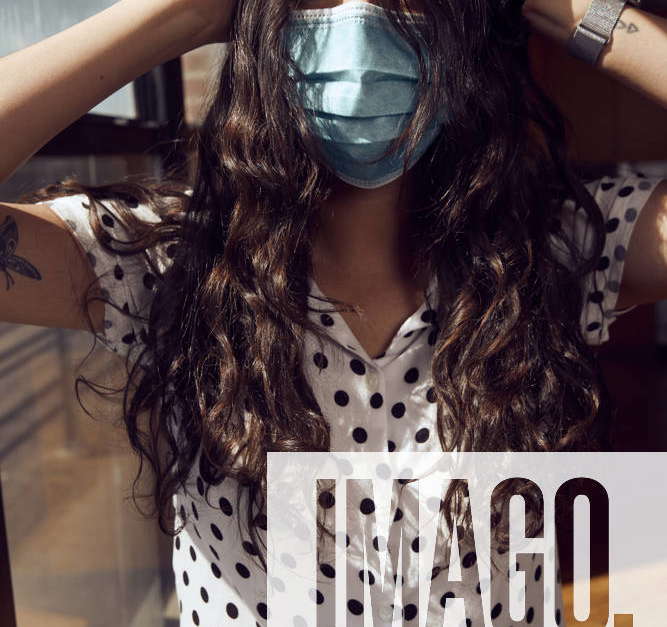 Portrait of young ethnic woman with face mask wearing polka dot blouse ...