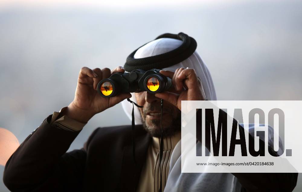 AMMAN, A man observes the crescent moon with binoculars in Amman ...