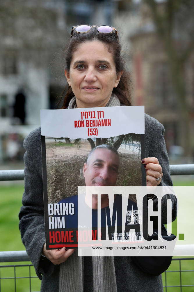 London, United Kingdom: Jackie Benjamin holds up a poster of Ron ...