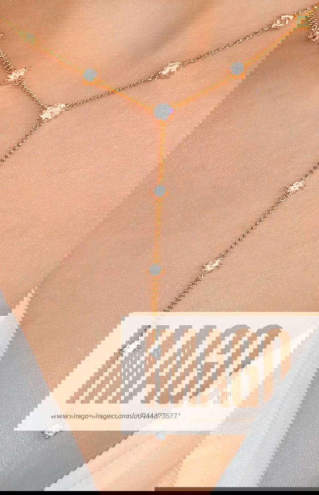 Young woman wearing a golden lariat necklace. A beautiful young woman ...