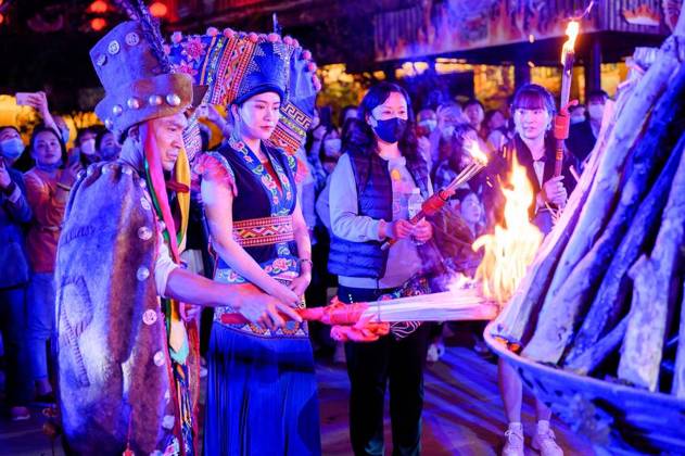 YUNNAN, Tourists take part in a campfire party at an ancient town of Yi ...