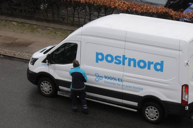 Copenhagen, Denmark 30 April 2024 .Postnord parcels and packets delivery van and postman from