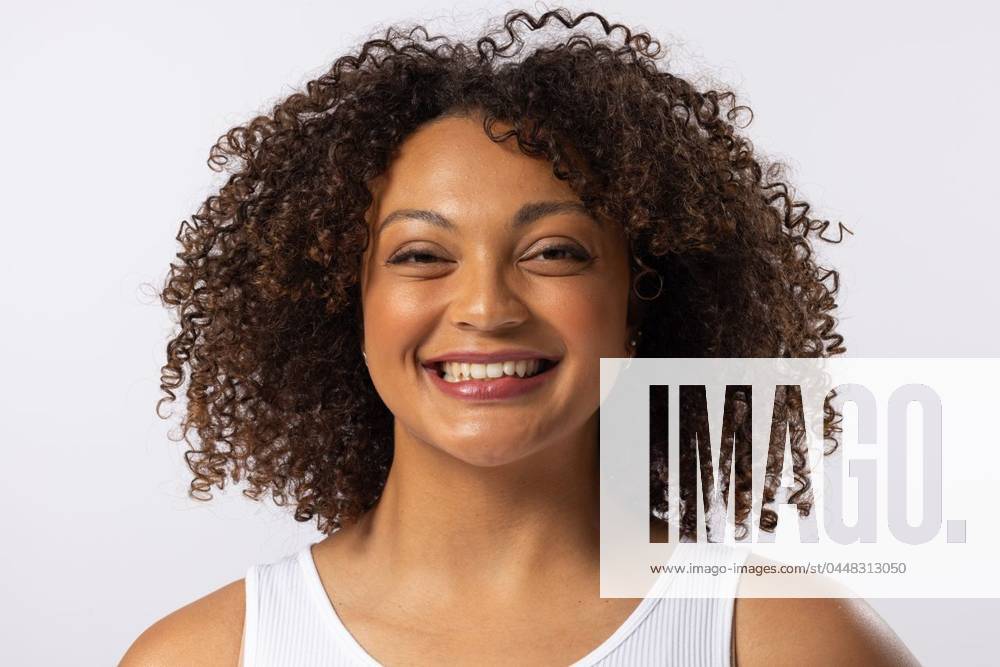 A biracial young plus size model smiles, wearing white tank top A ...