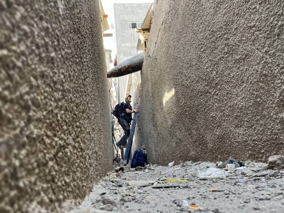 A team of foreign explosives experts inspects a huge unexploded shell ...