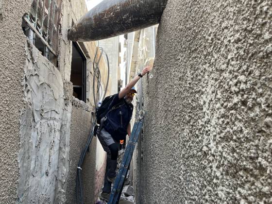 A team of foreign explosives experts inspects a huge unexploded shell ...