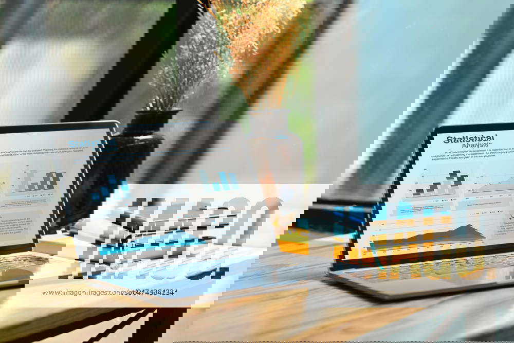 Laptop with financial diagrams graphs on wooden working desk. Business ...