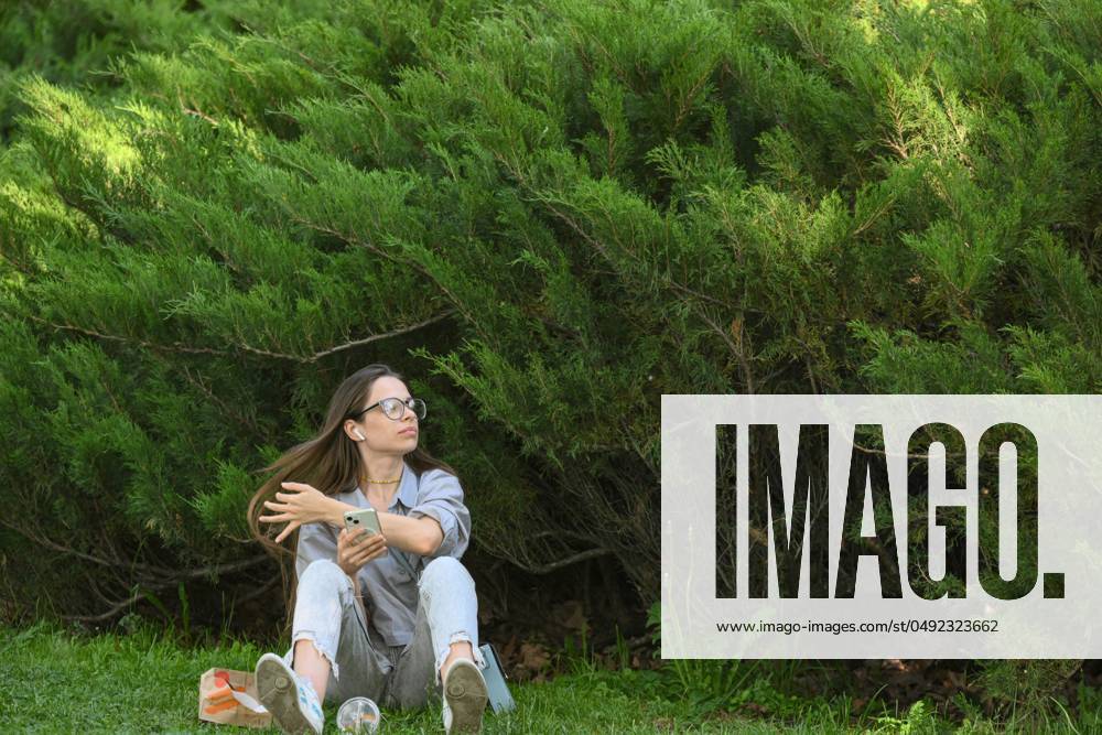 Russia Weather 8694286 29.05.2024 A woman sits on the grass in ...