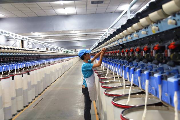 A Textile Company in Aksu AKSU, CHINA - A worker performs textile work ...