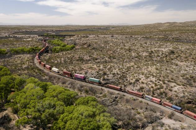 Aerial view of long container stack trains winding around curves United ...