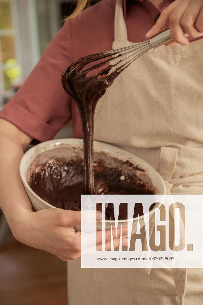 Woman mixing batter in a bowl in the kitchen, baking cake Corby ...